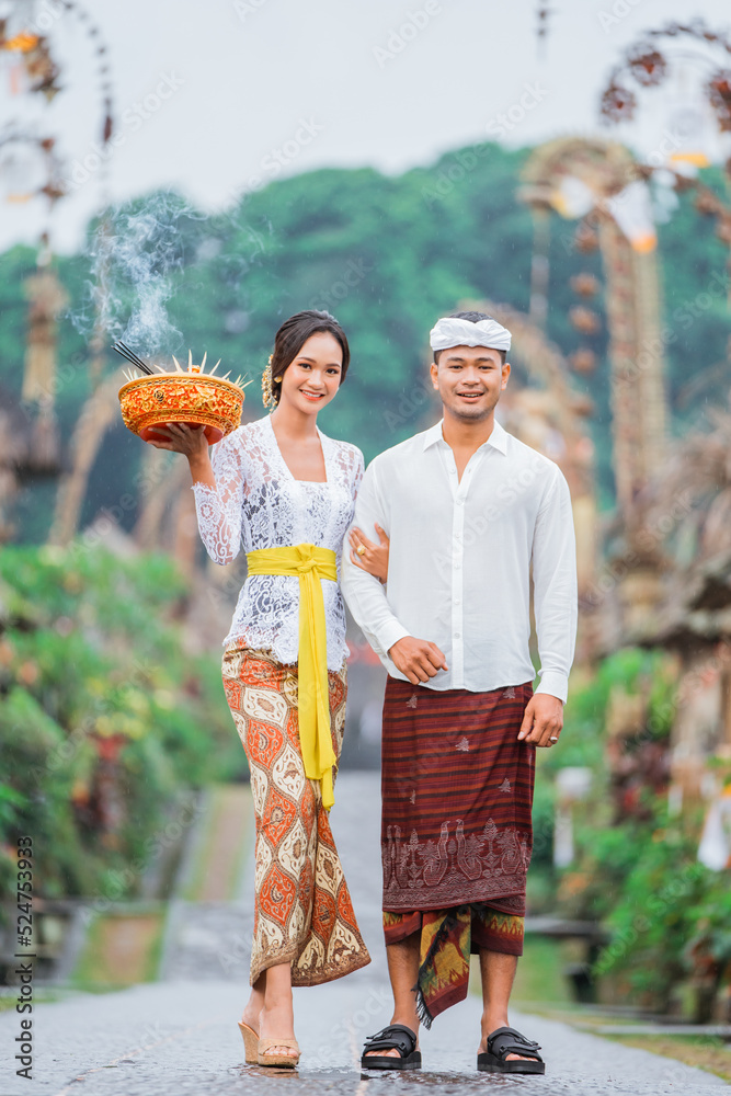 balinese couple walking in pengelipuran village wearing kebaya or ...