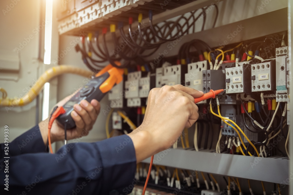 Electrical engineer using measuring equipment to checking electric ...