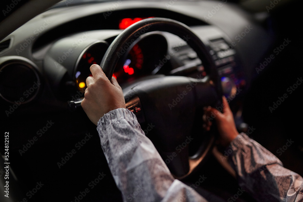 Anonymous woman driving car in night city Stock Photo | Adobe Stock