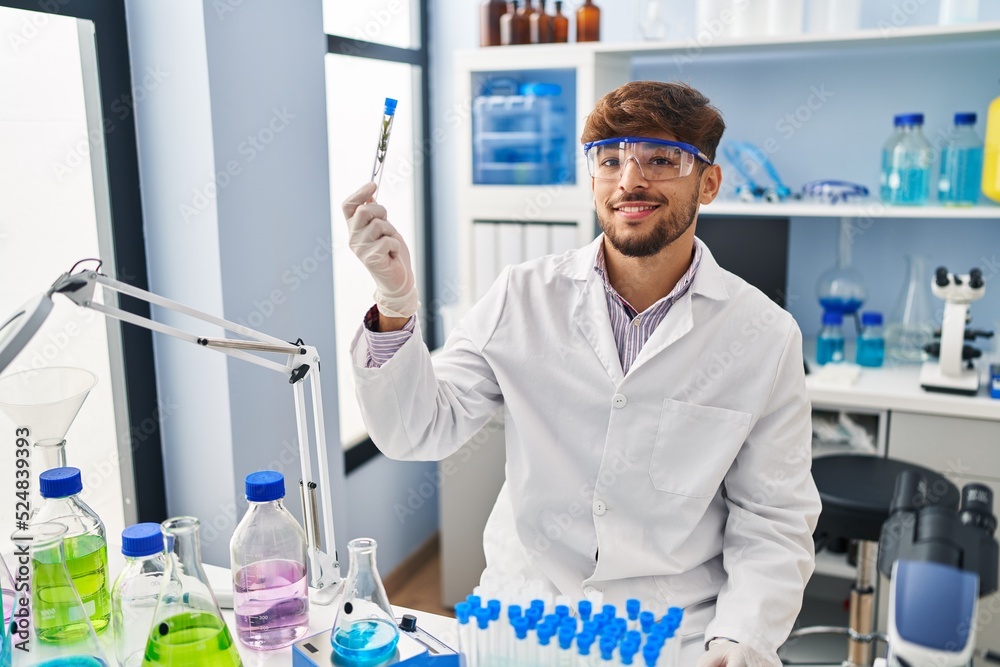 Young arab man scientist holding plant test tube at laboratory Stock ...
