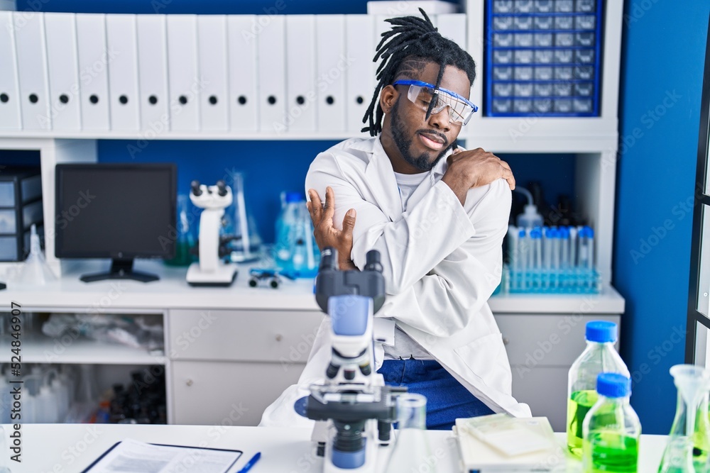 African man with dreadlocks working at scientist laboratory hugging ...