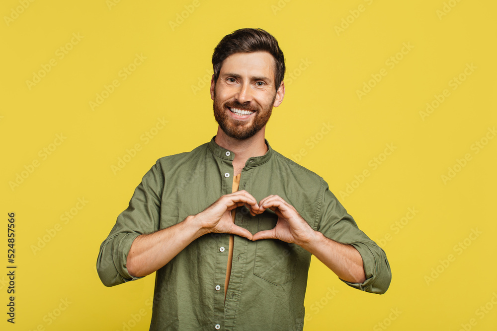 Kind man shaping hands like heart, making love gesture near chest ...