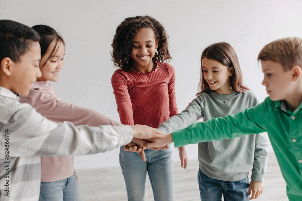 Happy Preteen Children Stacking Hands Together Standing In Circle ...