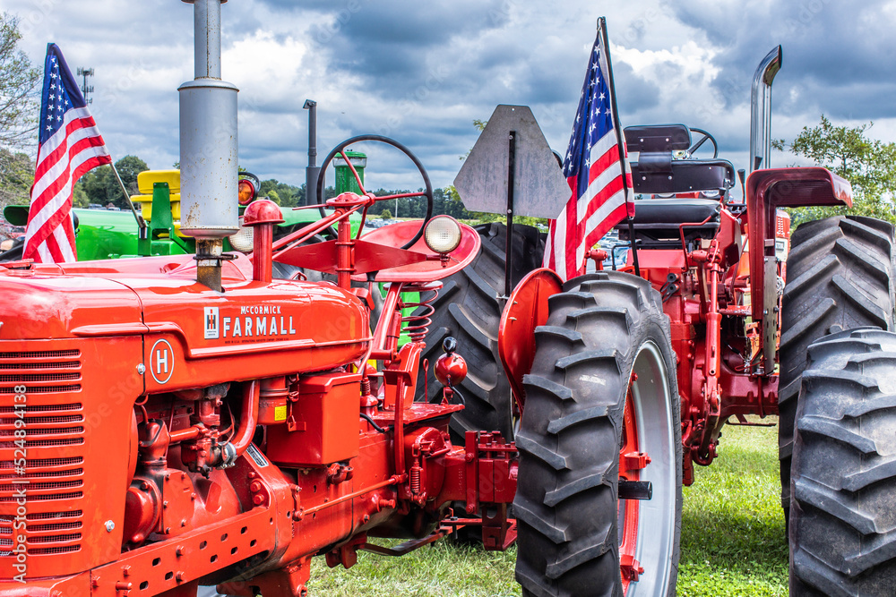 An International Farmall M tractor with two American flags at a farm ...
