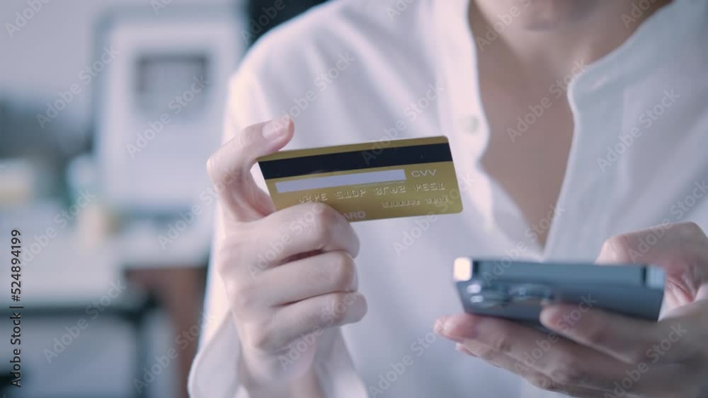 Close up view female hands holding credit card and smartphone makes ...