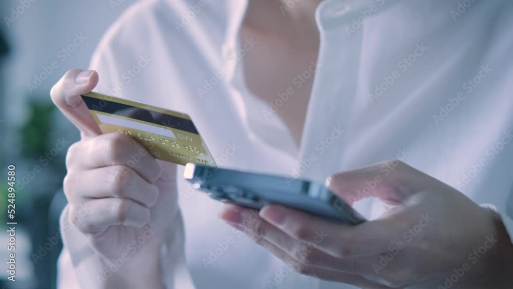 Close up view female hands holding credit card and smartphone makes ...
