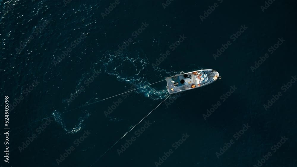 Commercial trawler boat tows netting bags which through water to catch ...