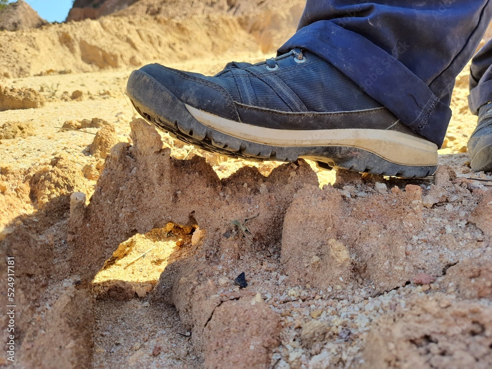 Boot stepping on an earth sculpture on the ground outdoors. Stock Photo ...