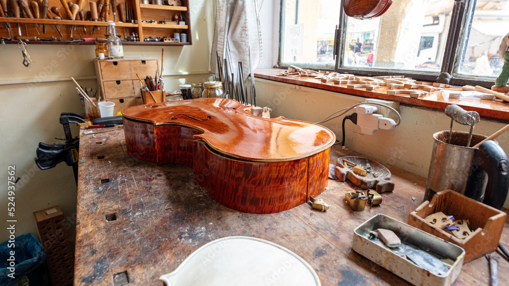 luthier attacching the front tables to the ribs of a cello in workshop ...