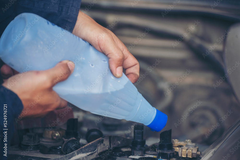 Foto de Car Mechanic man hands pouring Deionized purified Distilled ...