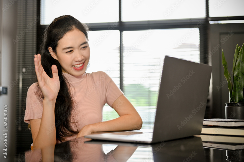 Beautiful Asian female waving hand to say Hi, video call with her ...