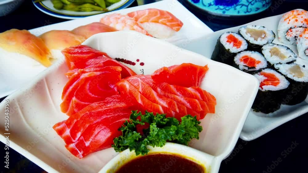 rotating plate of salmon sashimi with soy sauce mixed with wasabi and ...