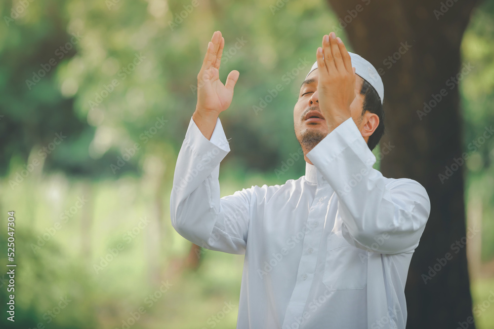 Religious muslim man traditional kandura praying outdoor at quiet ...
