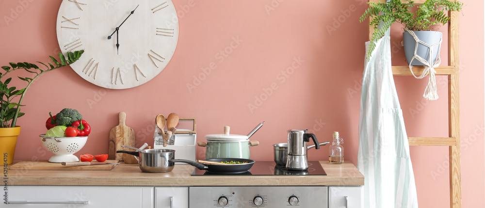 Modern electric stove with cookware and utensils in cozy kitchen Stock ...