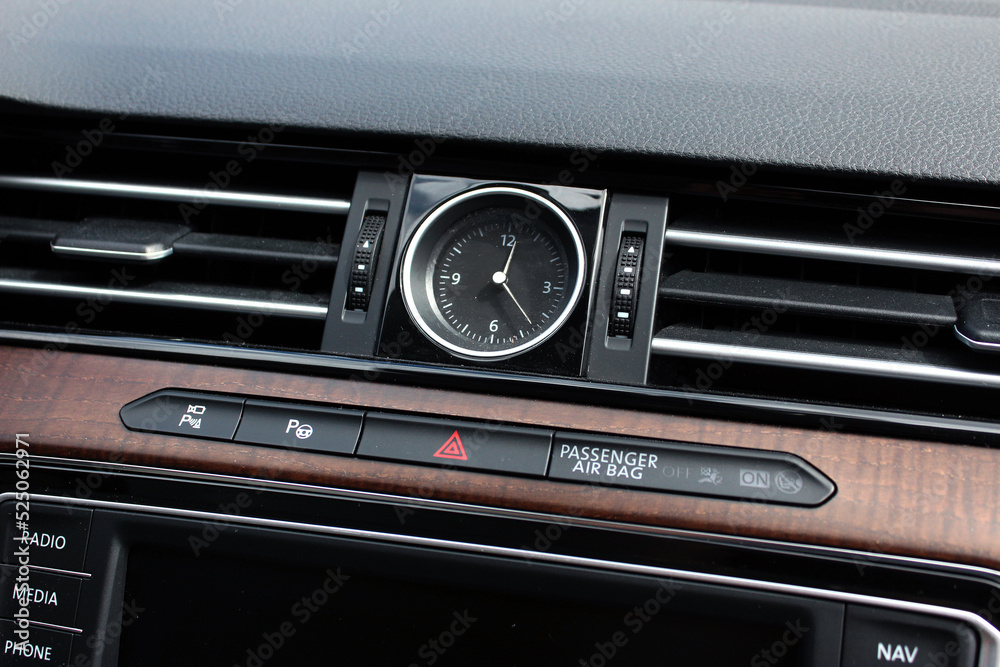Clock in the center interior car. Modern luxury car with natural wood ...