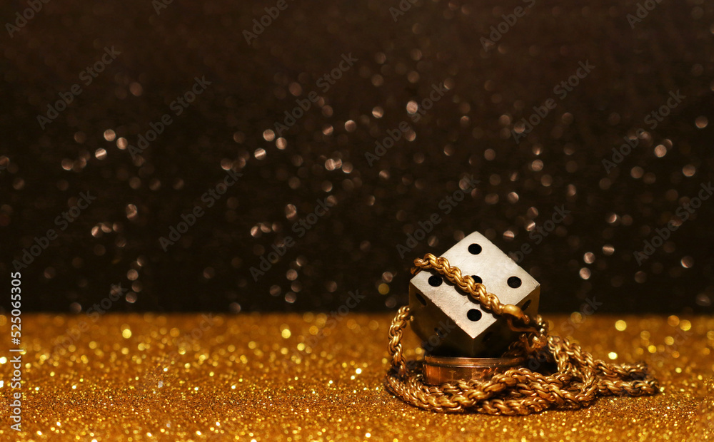 dice and gold chain conceptional pic taken in black and gold background ...