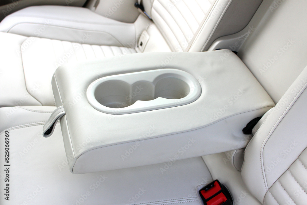 Armrest with cup holder inside. Leather comfortable white passenger ...