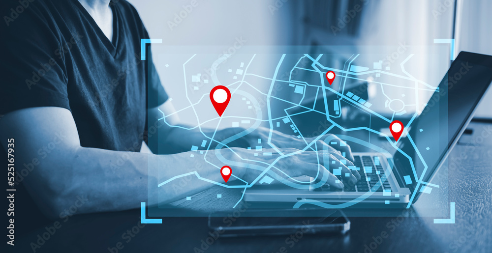 Man using laptop with virtual world and model map with location point ...