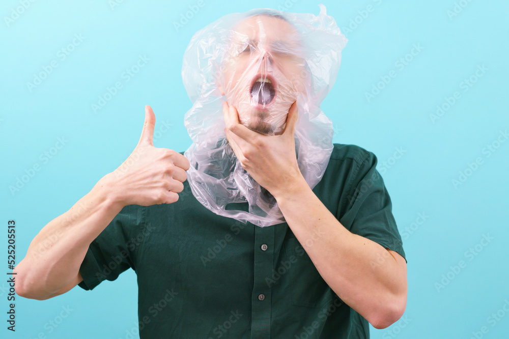 A man suffocating because of a plastic bag on his head shows his thumb ...