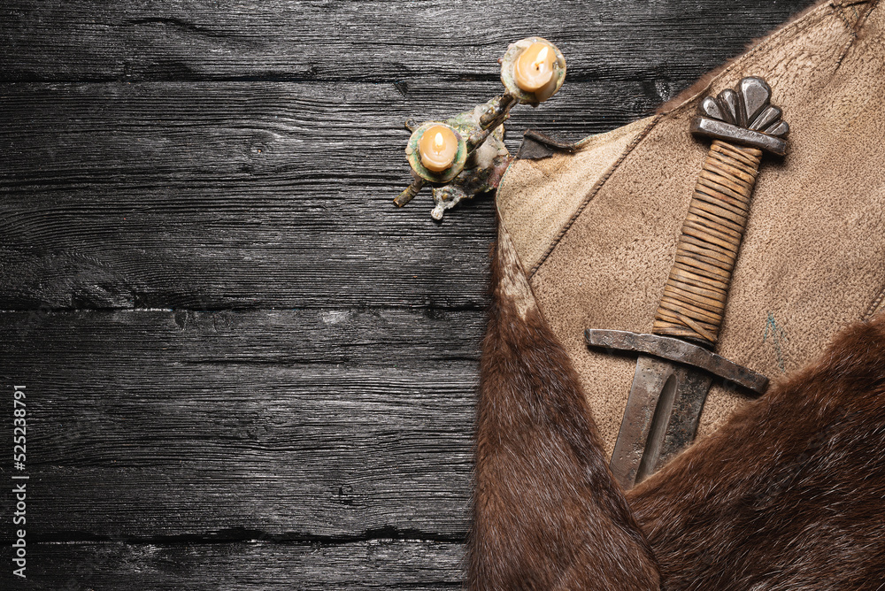 Ancient sword wrapped in the beast skin on the flat lay table ...