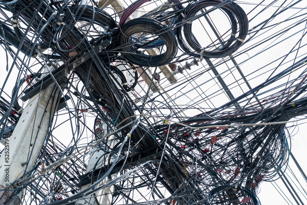 Tangled electrical wires on urban electric pole. Disorganized and messy ...
