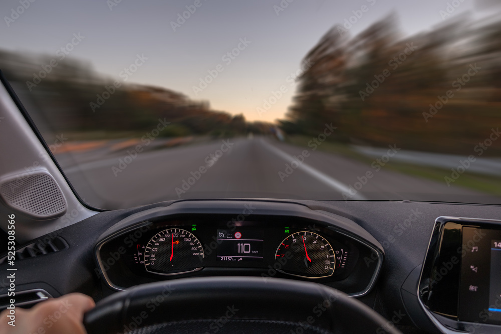 Driver view to the speedometer at 110 kmh or 110 mph and the road ...