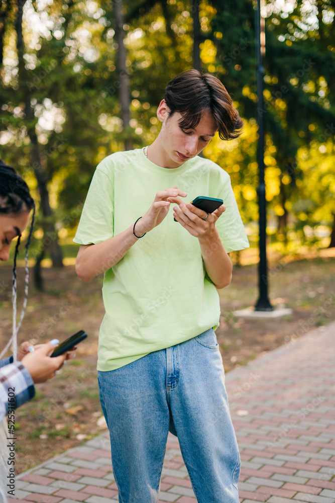 Freckled boy standing in the park with his friends being sad because ...