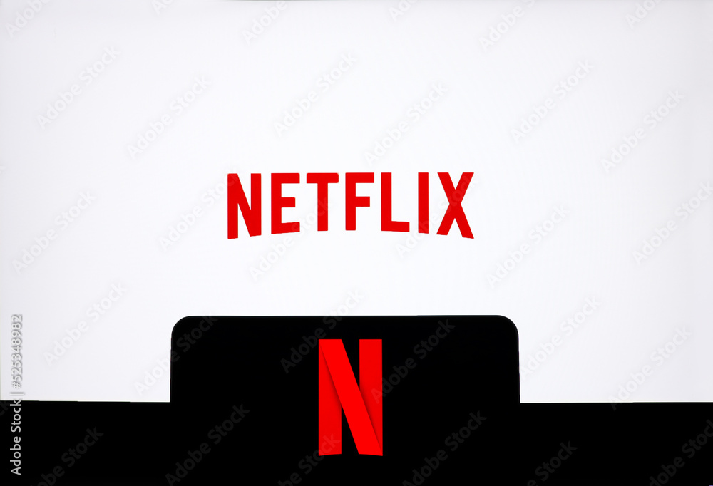 Netflix logo on smartphone screen and Netflix logo on computer ...