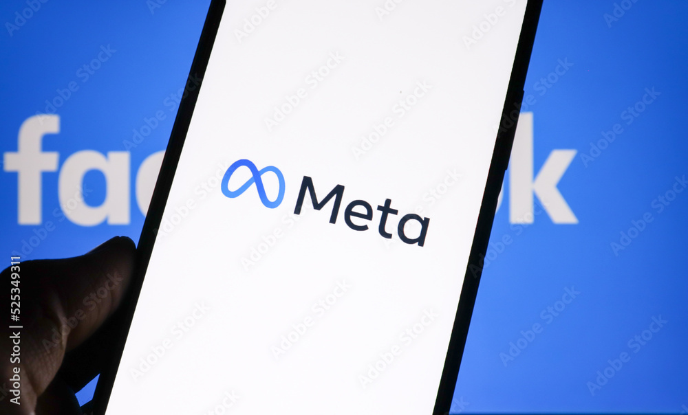 Meta logo on smartphone screen and Facebook logo on computer background ...