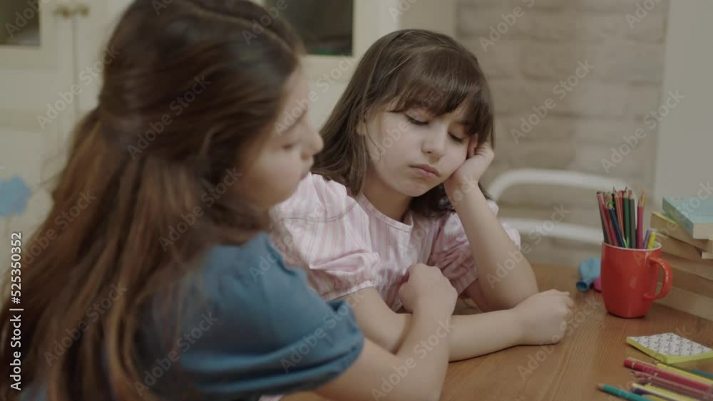 Little girl comforting her sad friend. She comforts him in his room and ...