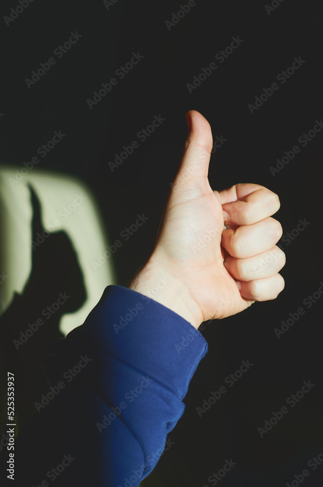 Man's hand makes gestures. Non-verbal communication. Thumb finger up as ...