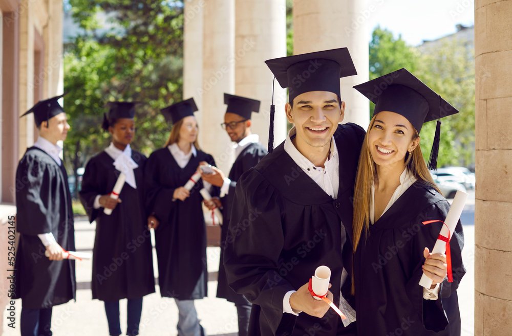 Happy friends on graduation day. Portrait of two cheerful joyful ...