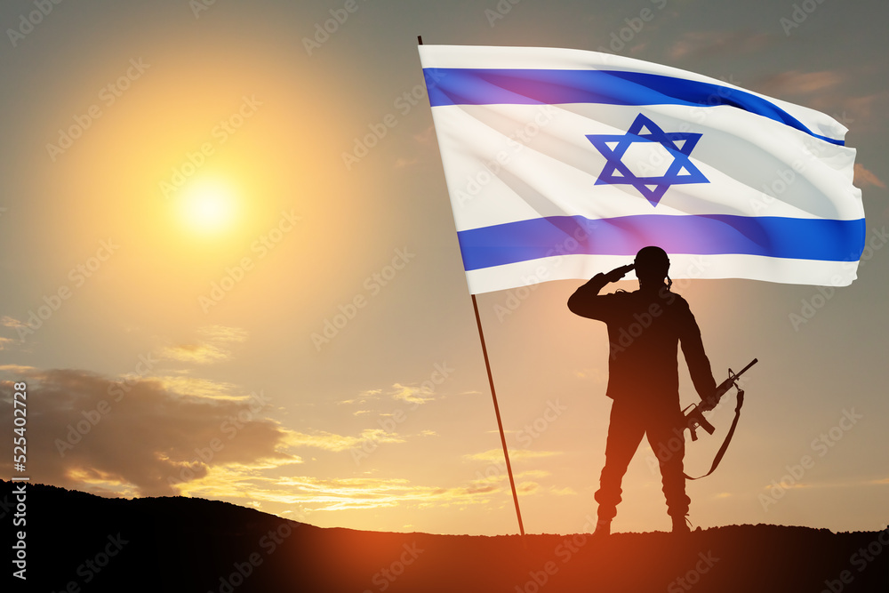 Foto de Silhouette of soldier saluting with Israel flag against the ...