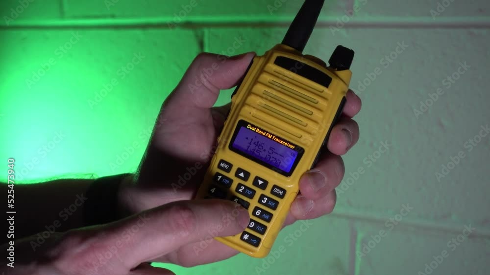 Entering a frequency into a yellow handheld amateur radio then ...