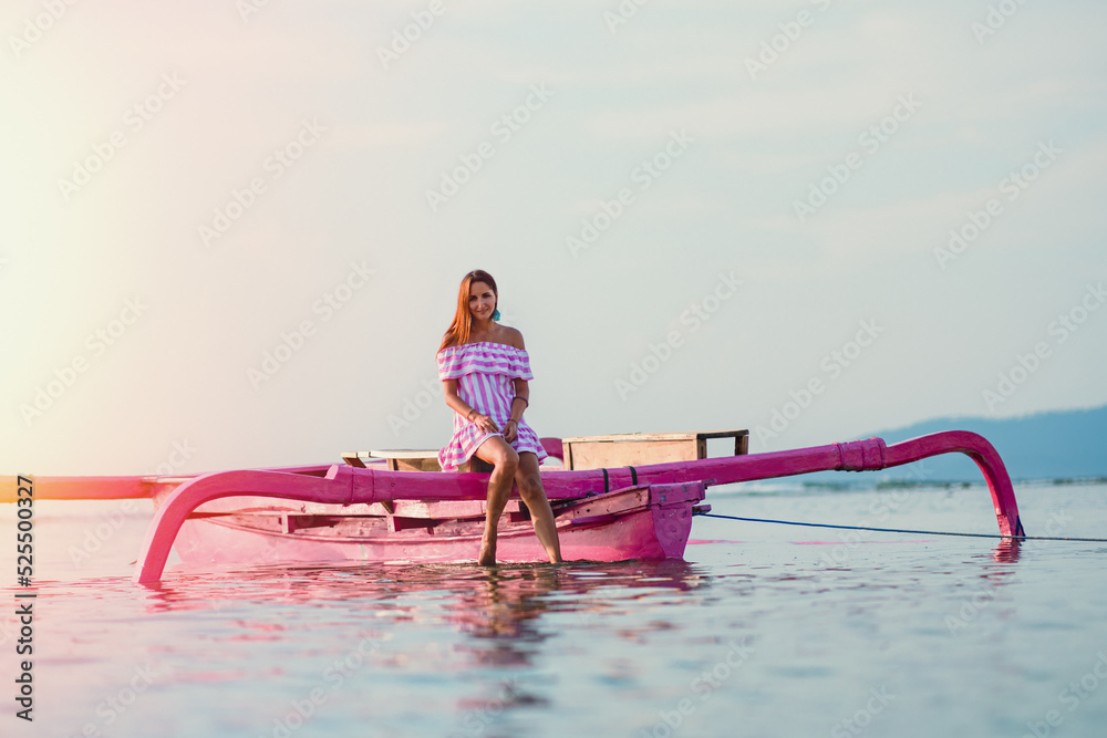 Walk on the boat. A beautiful young woman in a striped sundress poses ...