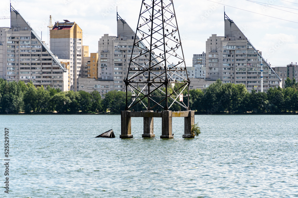 Metal poles of high-voltage power lines in water on concrete base ...