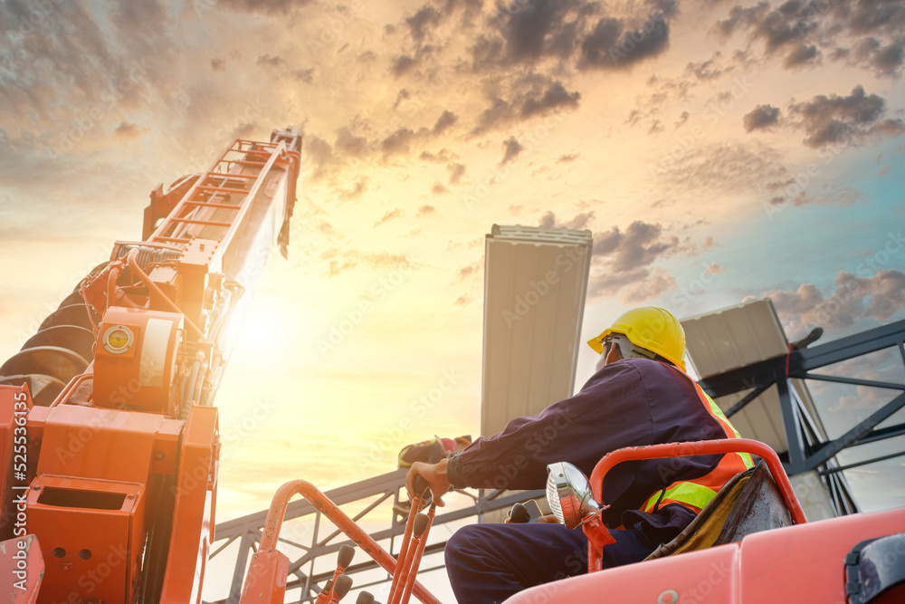 Construction workers are driving cranes to use cranes to lift large new ...