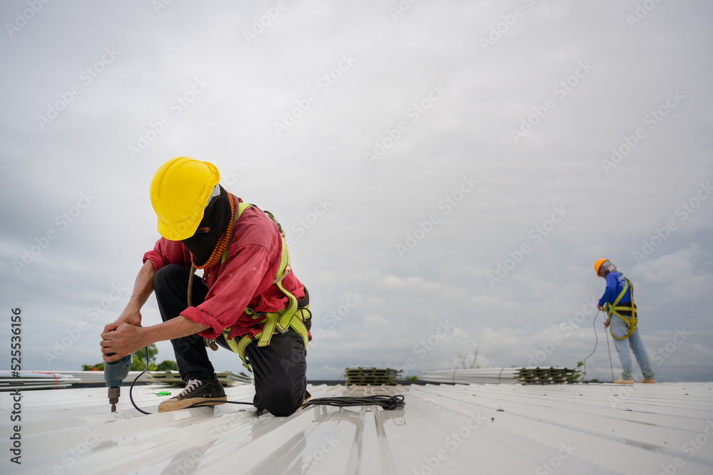 Construction workers work installing new roofs on houses and buildings ...