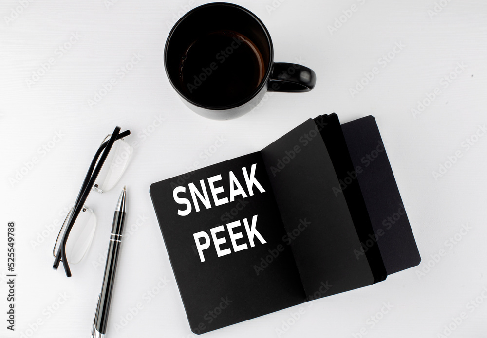 SNEAK PEEK written text in small black notebook with coffee , pen and ...