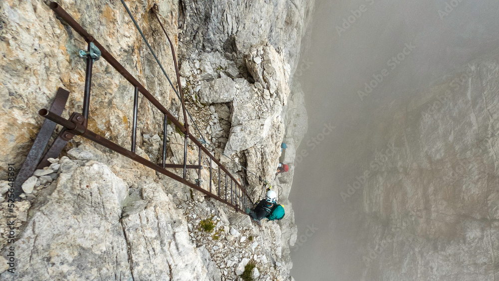 climbing a ladder of the via ferrata "via delle bocchette" mountain ...