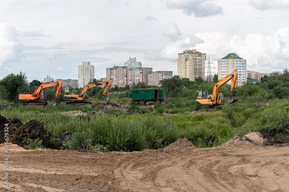 Crawler excavators dig the earth with a bucket. Road construction works ...