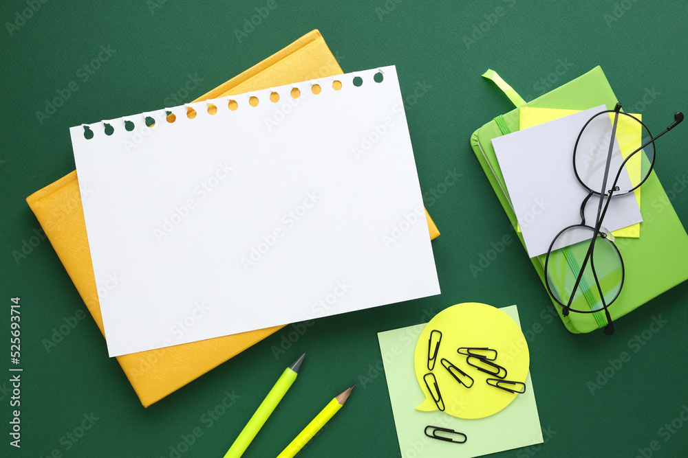 green background with empty notebook and glasses. green notepad and ...