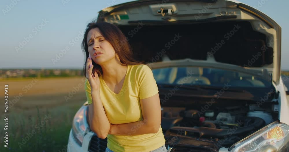 Vidéo Stock Upset young woman driver talking angrily on cell phone with assistance service near ...