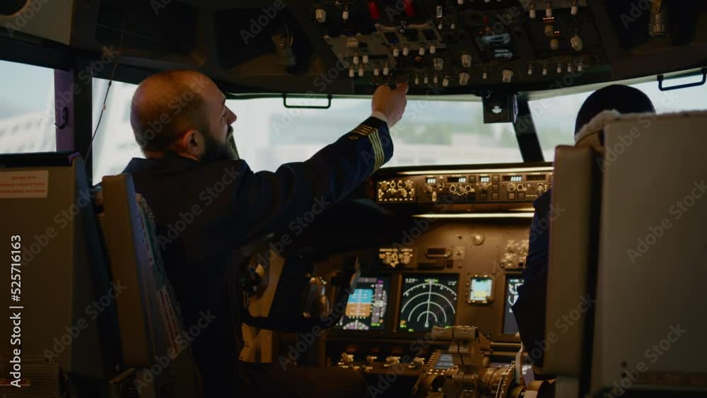 Diverse captain and copilot switching power buttons to fly airplane ...
