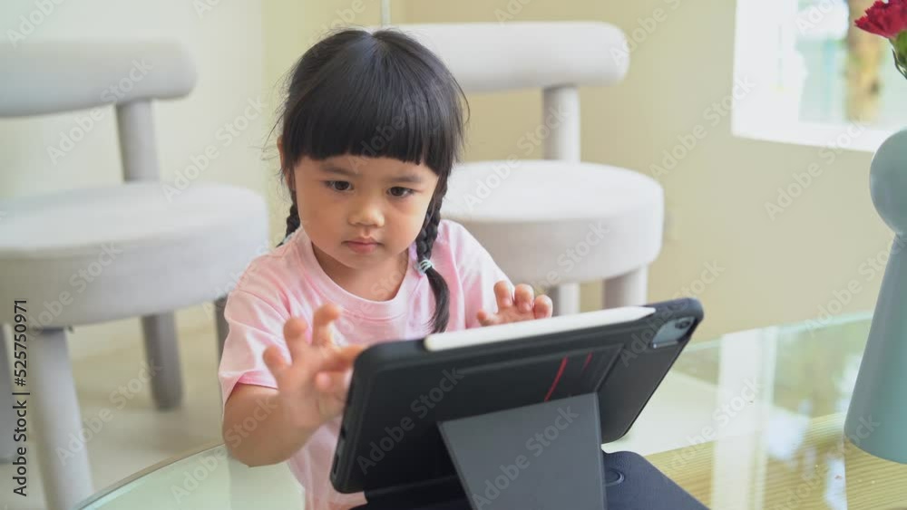 Asian girl looking and touch on screen at the tablet screen attentively ...
