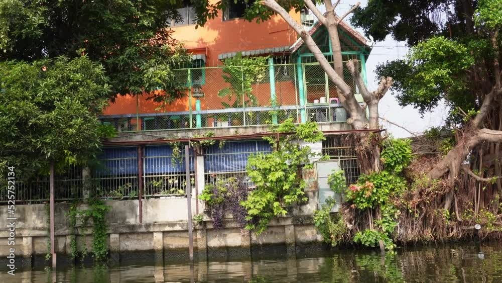 A very old and worn out house in the backwaters of Bangkok, with a huge ...