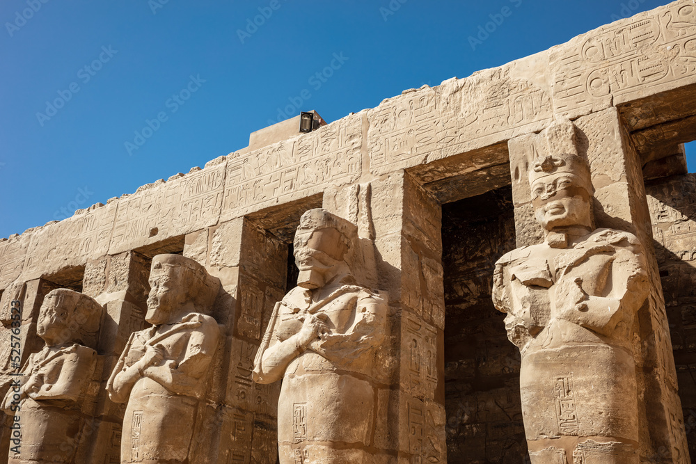 Statues of ancient Egyptian pharaohs and gods. Various hieroglyphs on ...