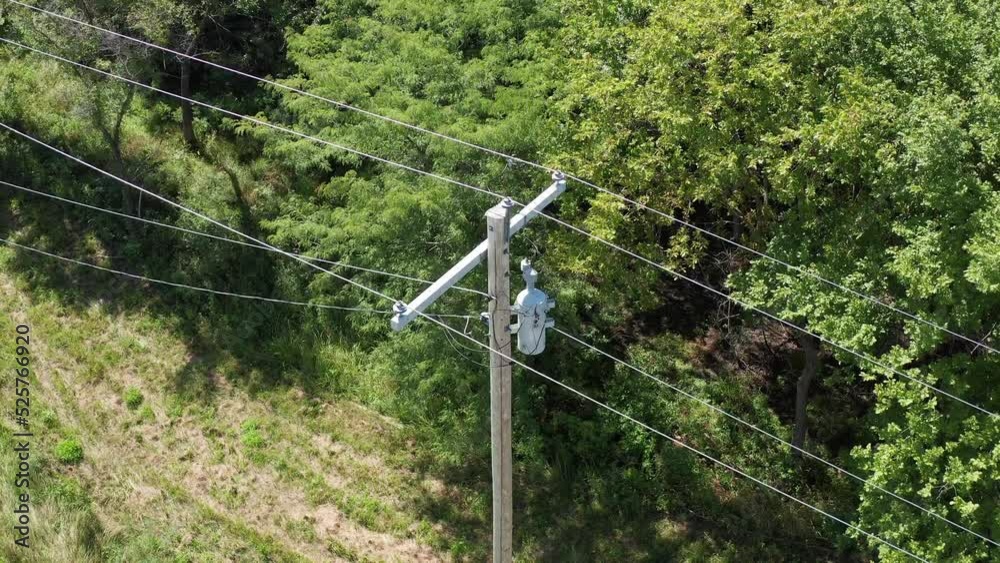Extreme close-up aerial shot tilting down on a rural utility pole and ...