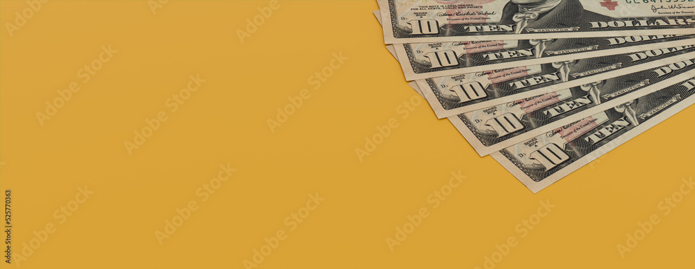Ten Dollar Bills on a Yellow surface. Wealth concept Banner with copy ...
