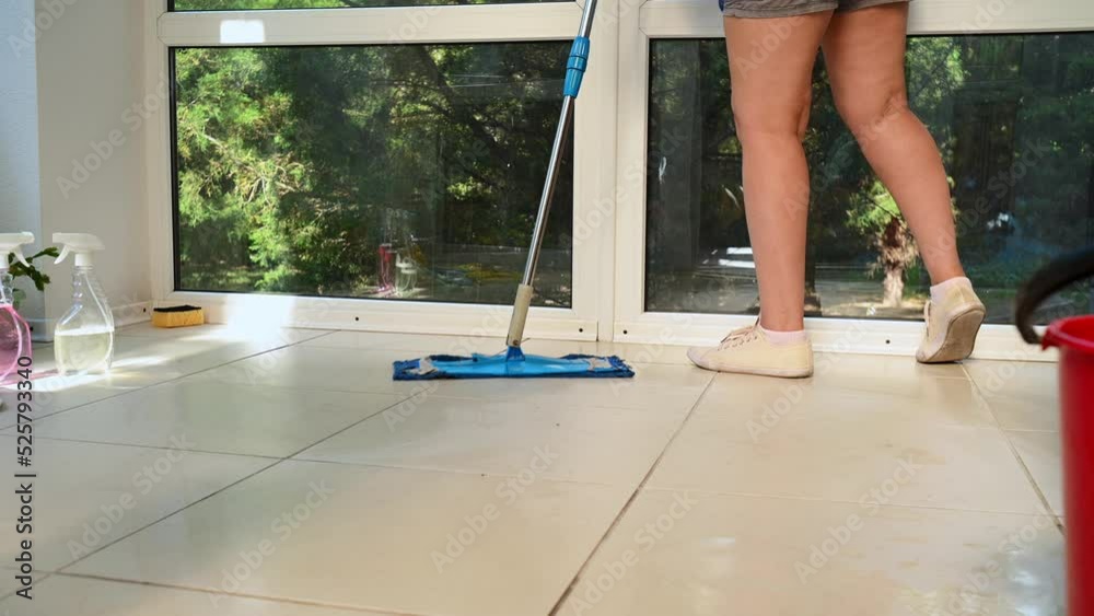 Details: legs of a housewife or maid mopping the floor in the house ...